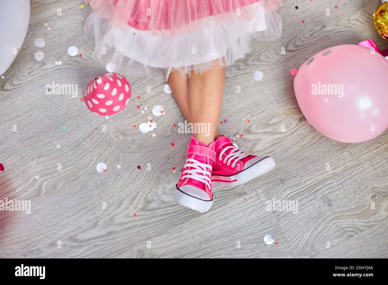 Creative lay out of funky leg of girl in pink sneakers and dress, flat ...