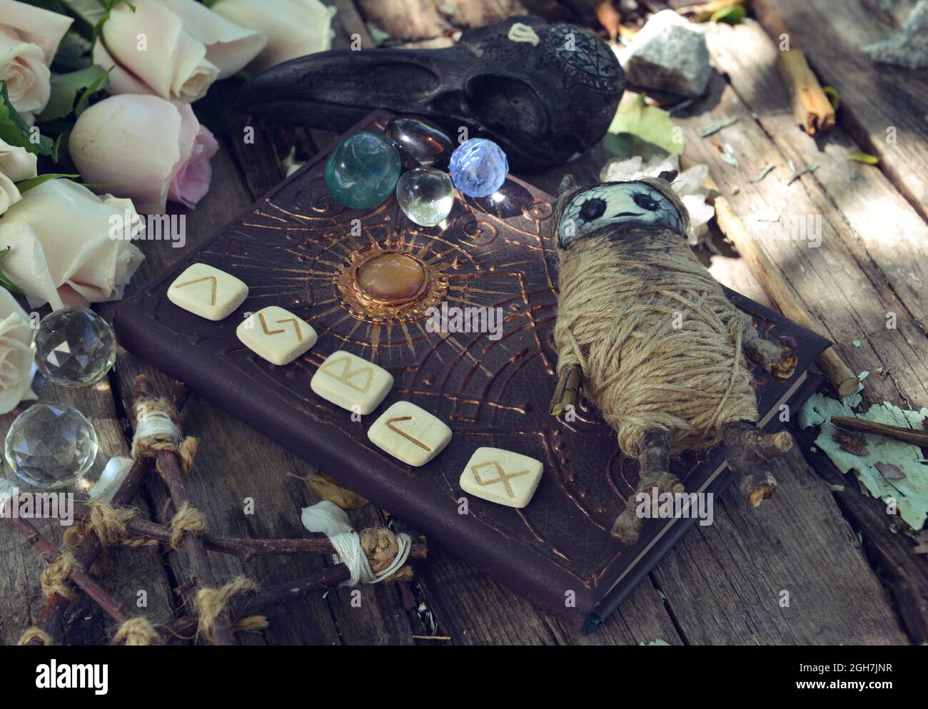 Voodoo doll, runes, witch book with magic spells and pentagram on the ...