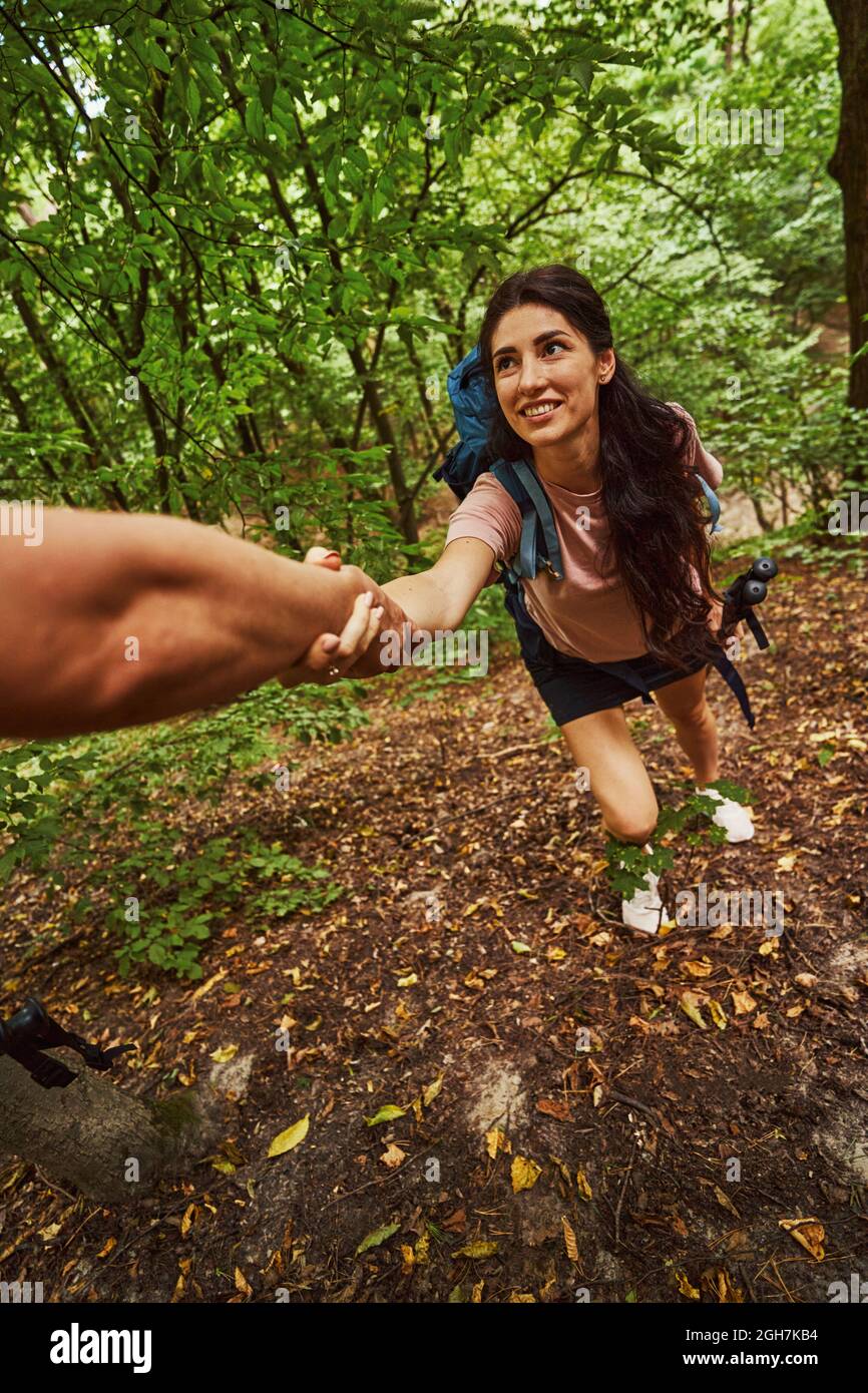 Happy sporty female following boyfriend in forest Stock Photo - Alamy