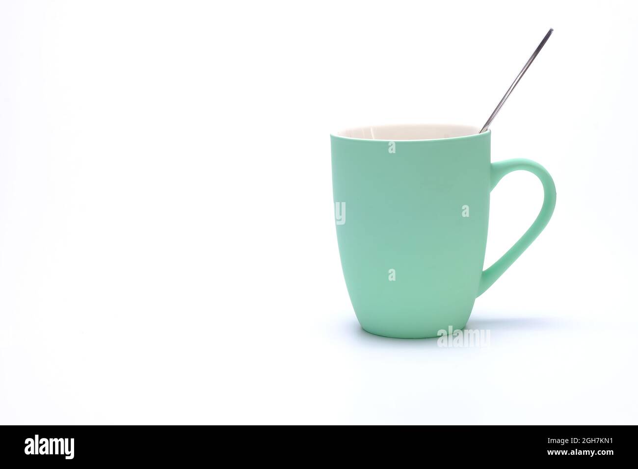 green coffee mug with spoon isolated on white background Stock Photo ...