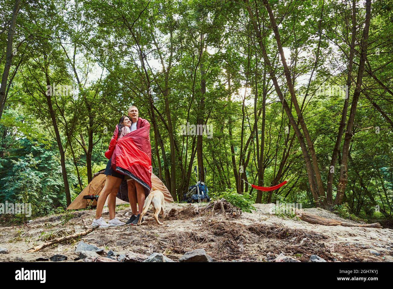 Happy romantic couple going camping in forest Stock Photo - Alamy