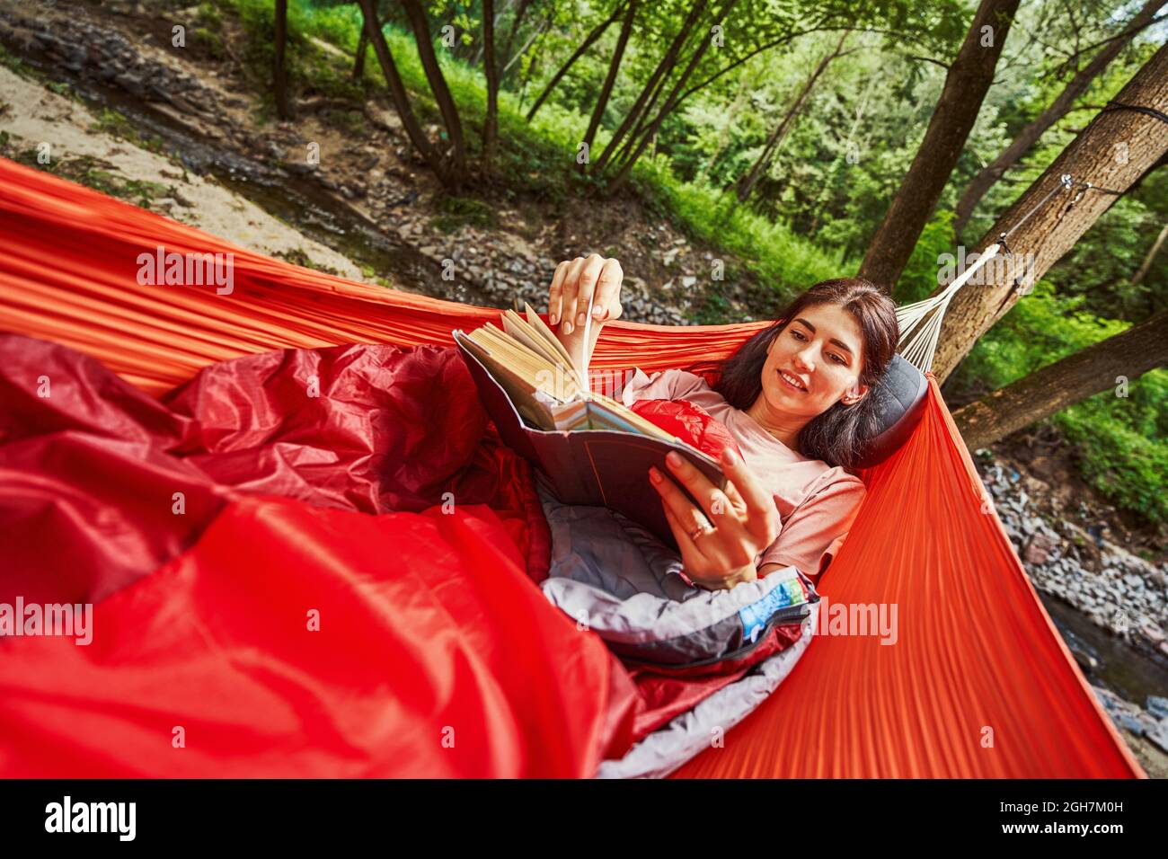 Happy young woman relaxing with book outdoors Stock Photo - Alamy