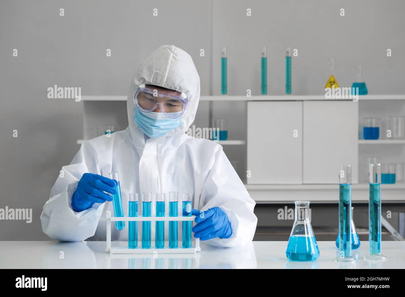 Epidemiological researcher in virus protective clothing look at blue ...