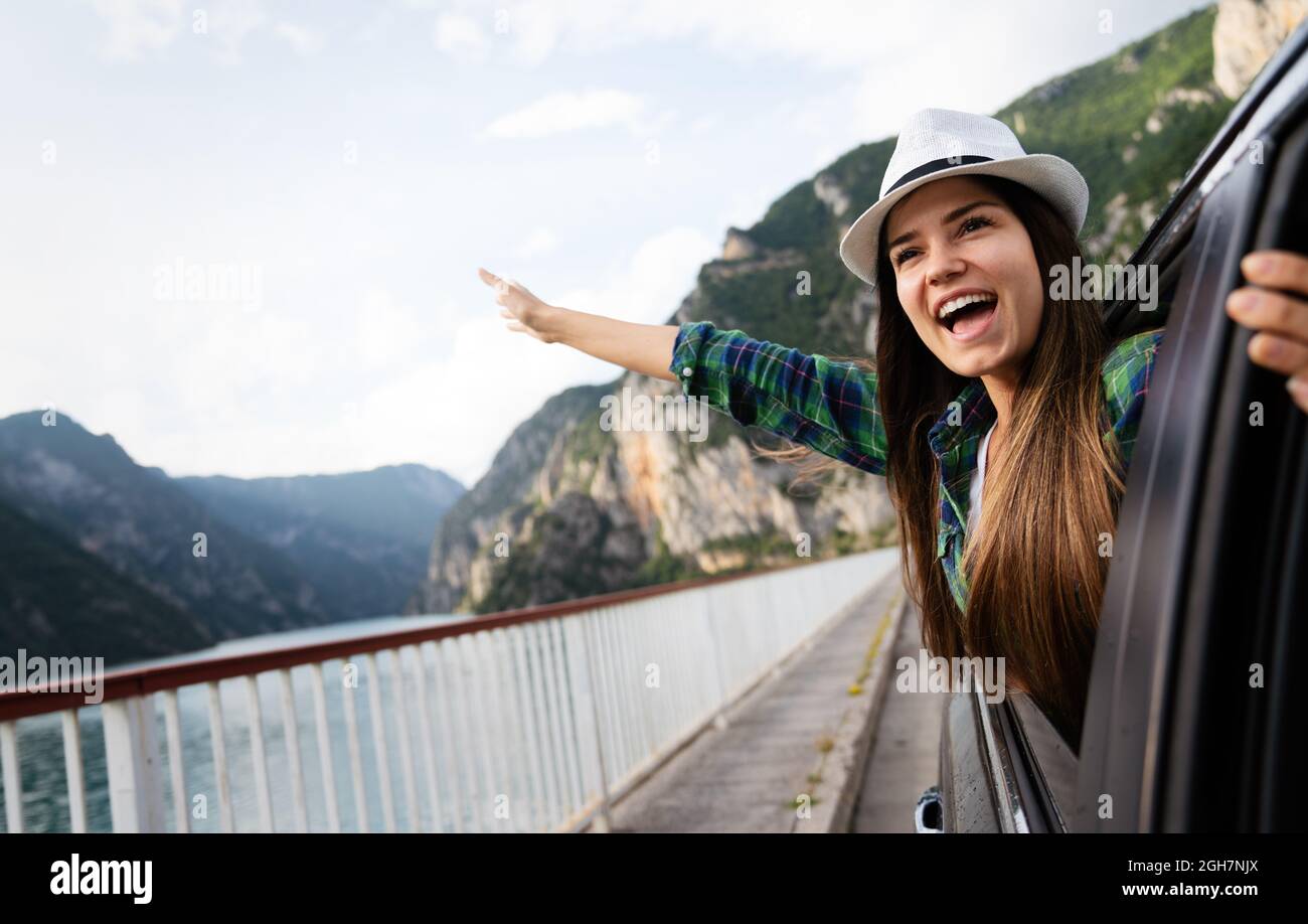 Woman in car road trip waving out the window smiling Stock Photo - Alamy