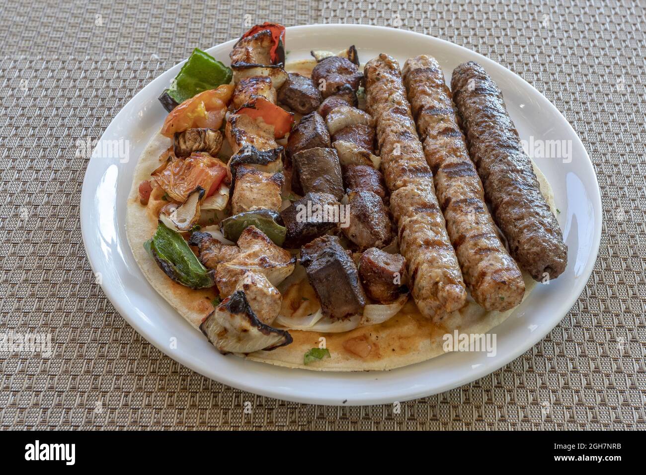 Close of Kebab, meat, and of Shish taouk on a white plate on a gray ...