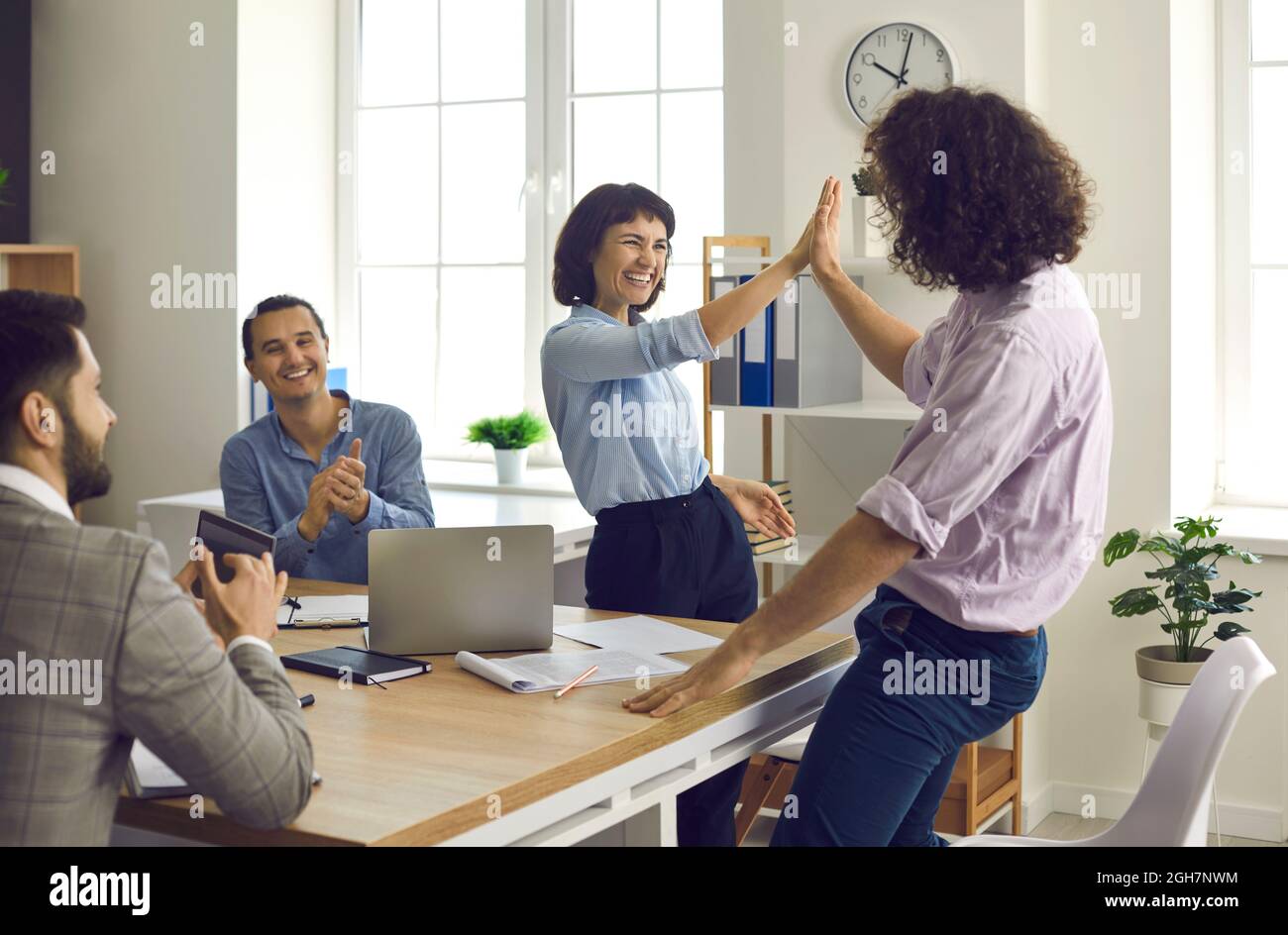 Two happy and satisfied colleagues give each other five during a ...