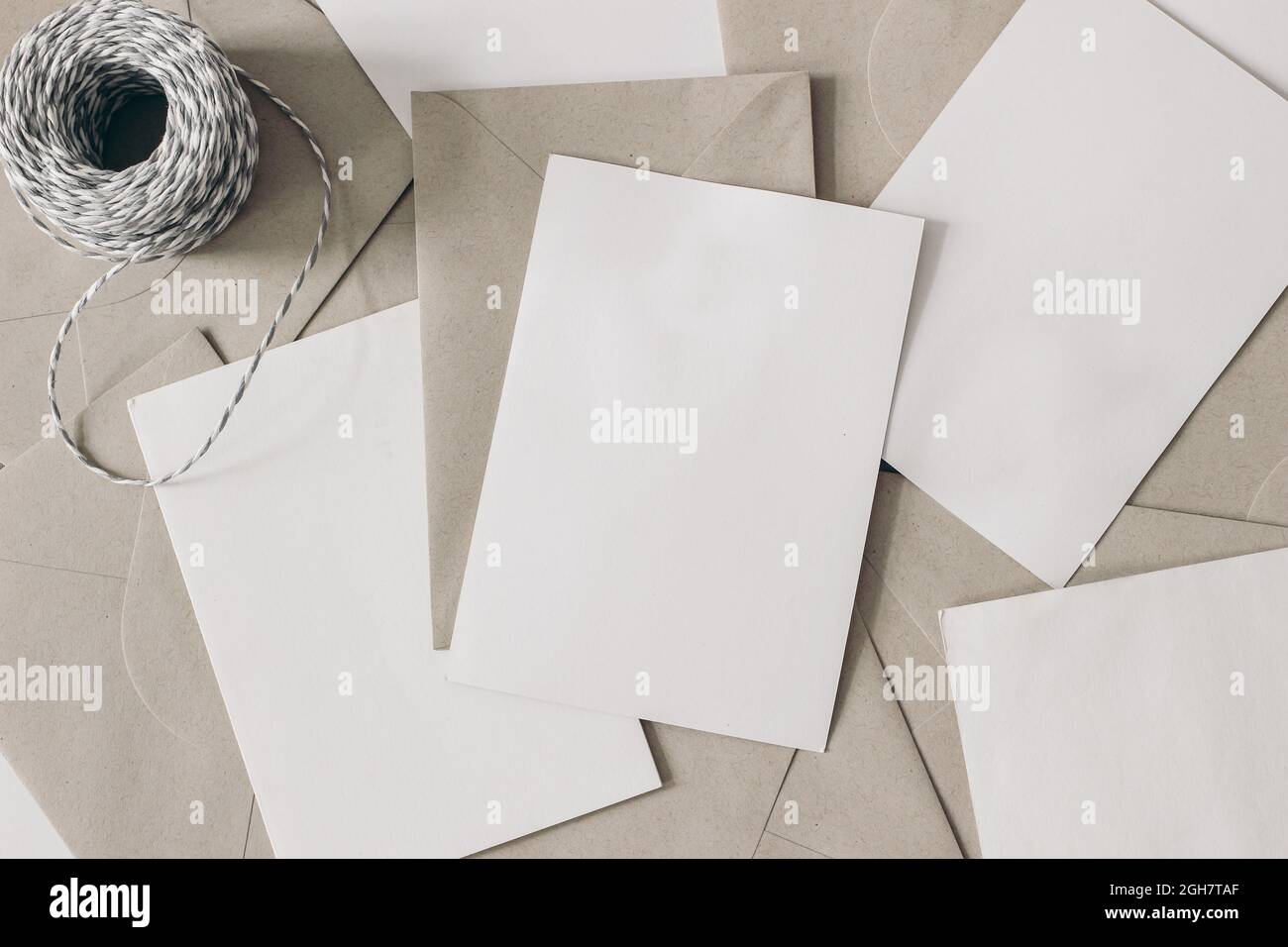 Pile of blank letters with craft envelopes and decorative rope on table ...