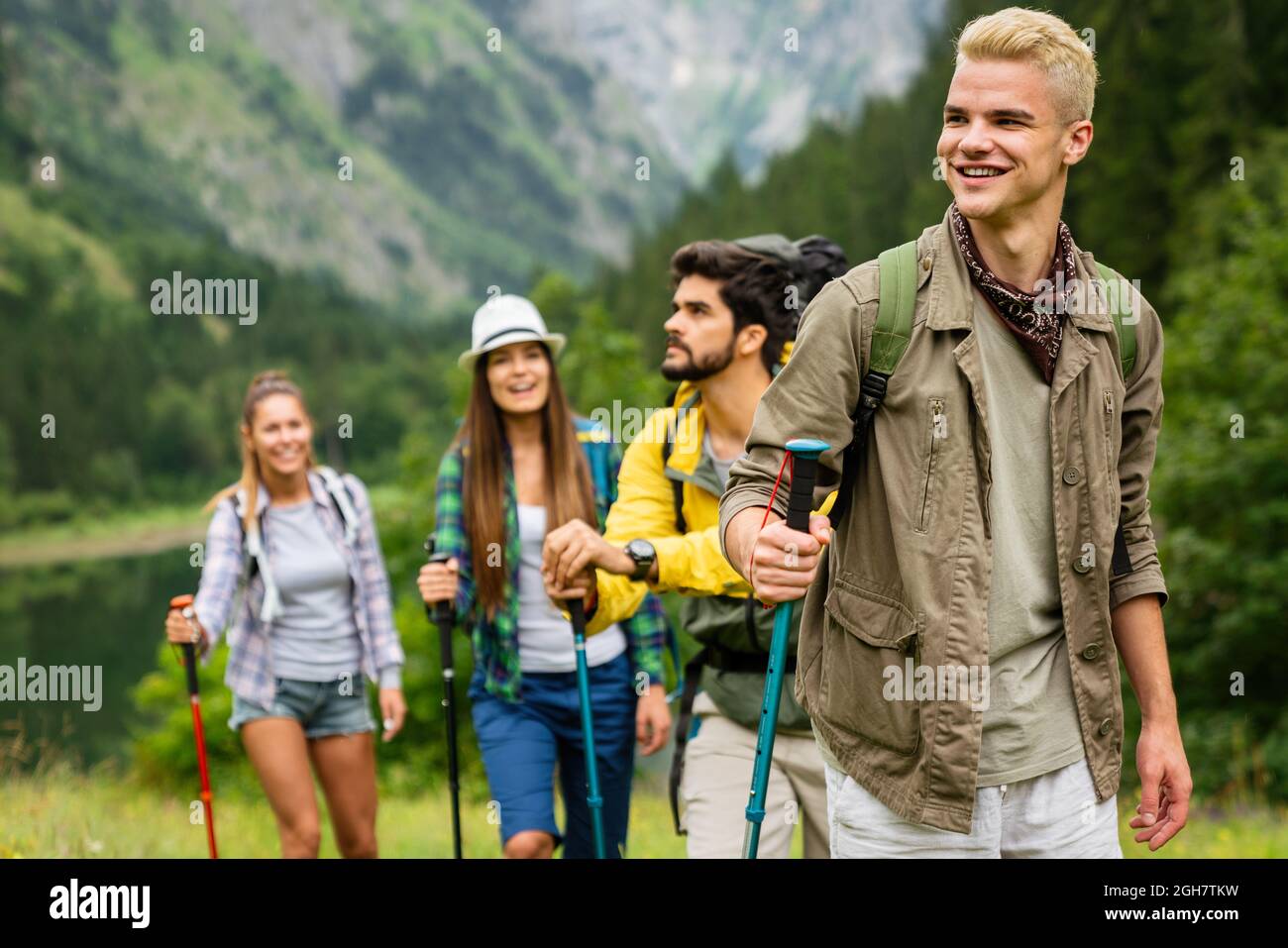 Group of friends hiking together outdoors exploring the wilderness and ...