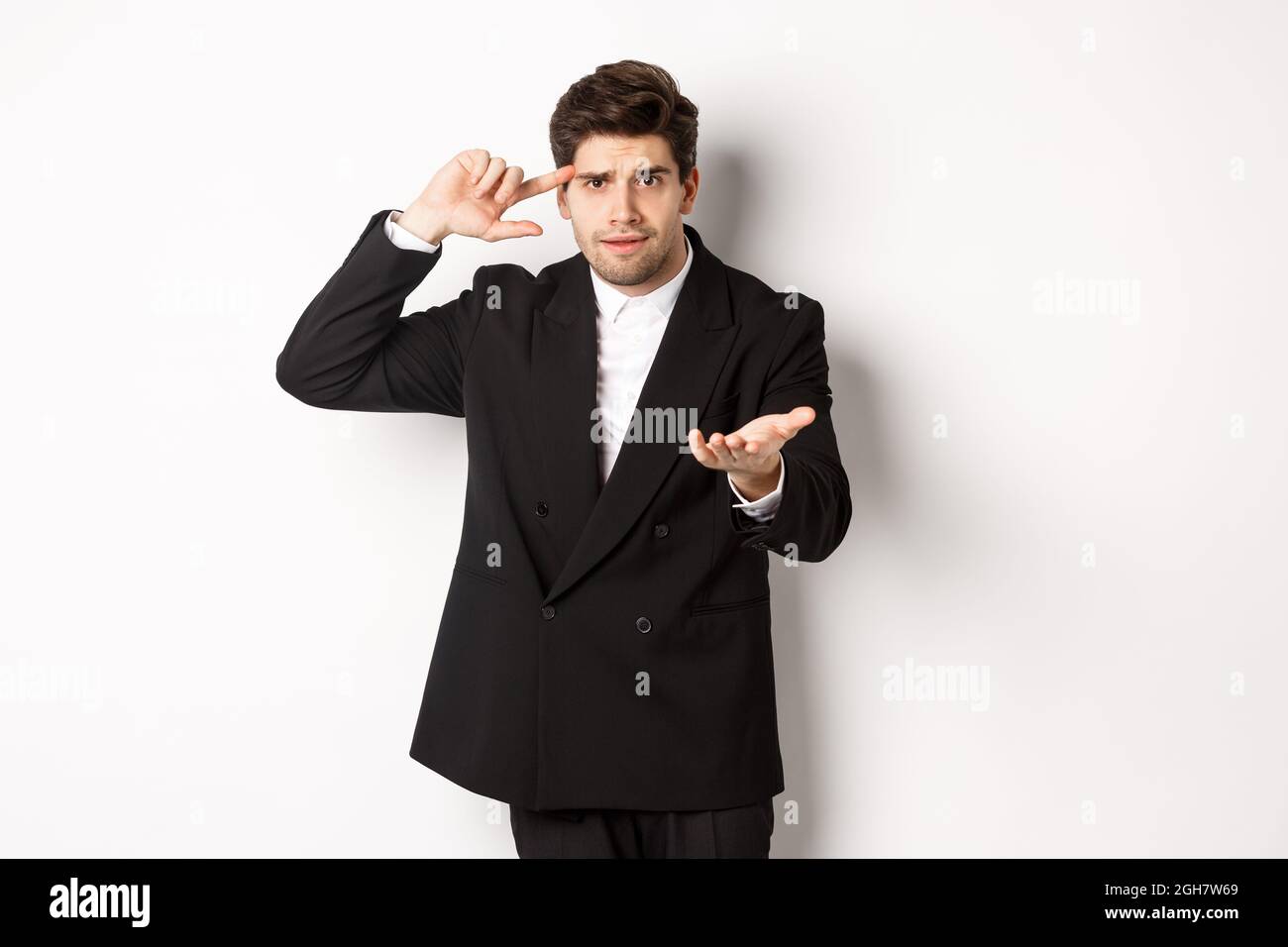 Portrait of confused handsome businessman scolding employee, pointing ...