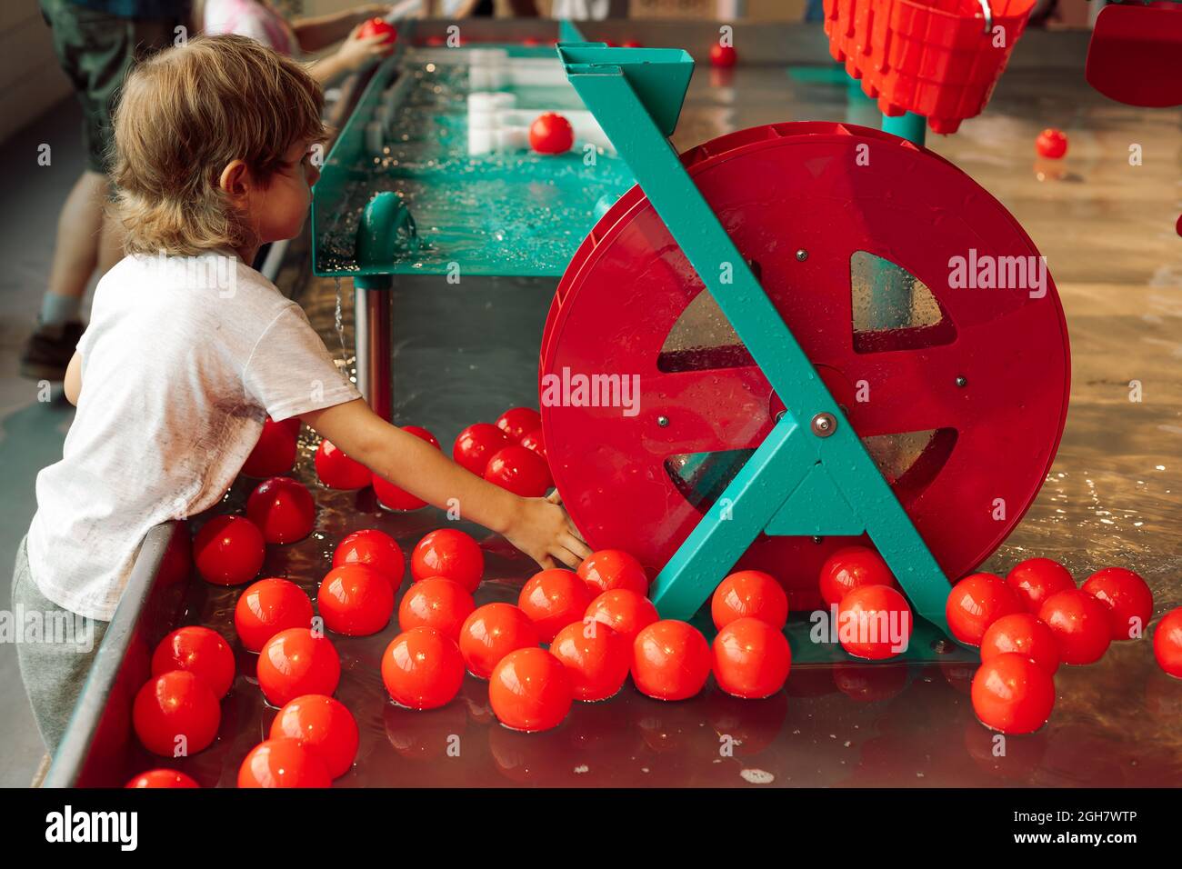 Bright water equipment and balls completely captured attention ofboy in ...