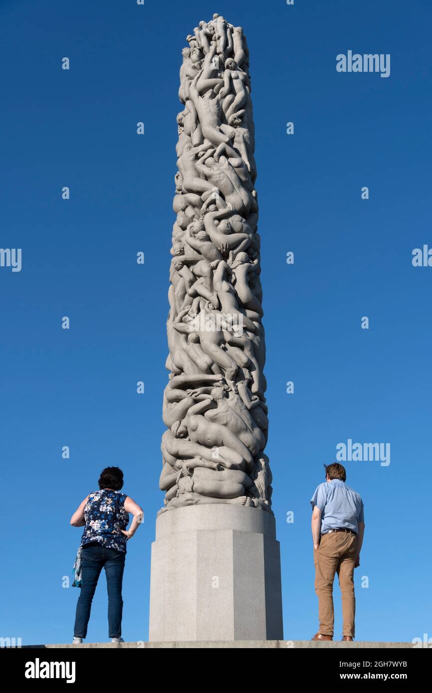 Two people look at the 121 figures of The Monolith column by norwegian ...
