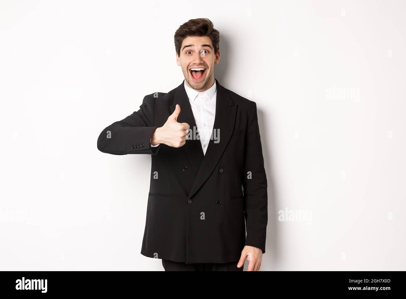 Portrait of amazed and impressed handsome man in black suit, showing ...
