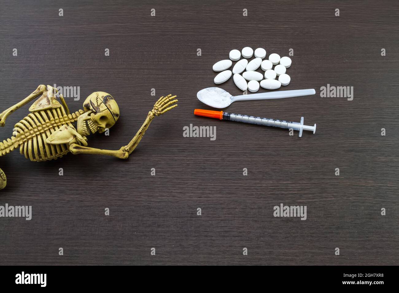 Skull and drugs with insulin syringe. Next to them are a spoon with ...