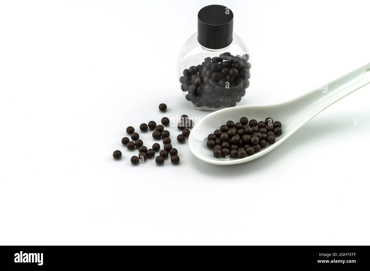 Black pills of traditional medicine or Black bolus near bottle and ...