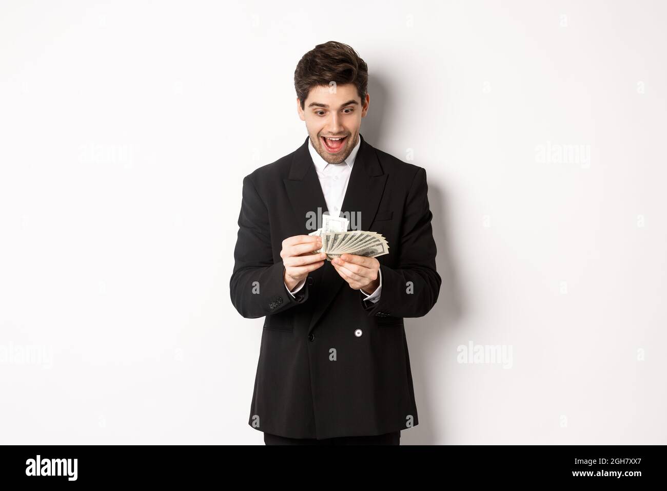 Image of excited handsome businessman, counting money and smiling ...