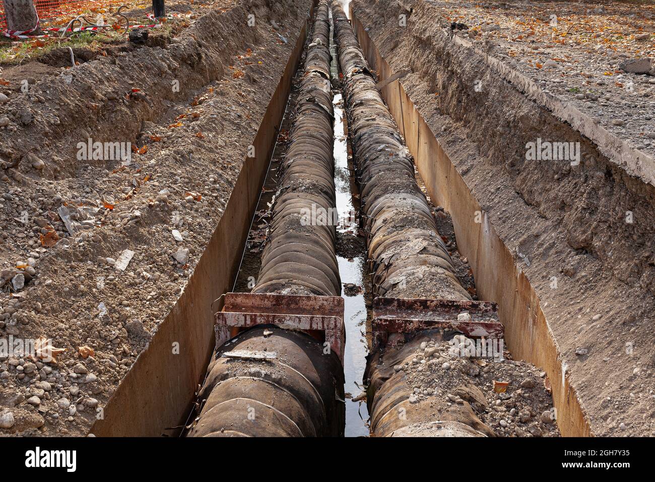 Big pipes in hole in the ground covered with dirt, construction site ...