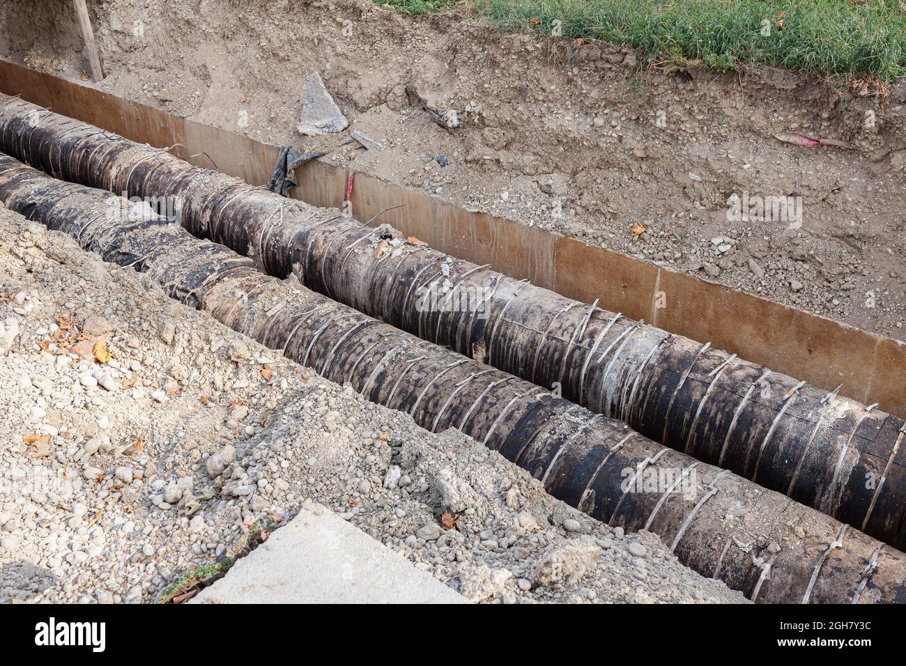 Big pipes diagonal in hole in the ground covered with dirt ...