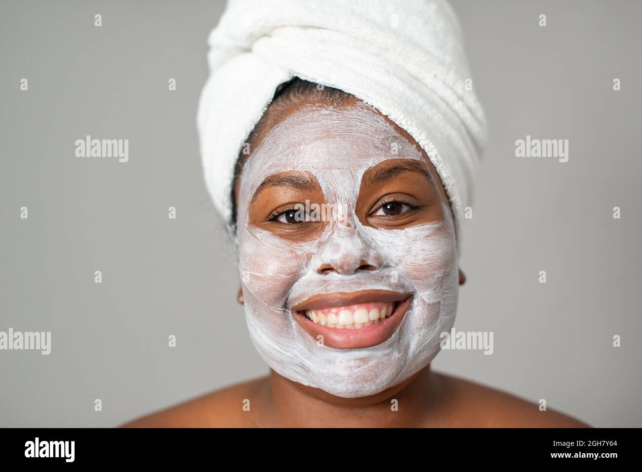 Glad African American female with clay mask Stock Photo - Alamy