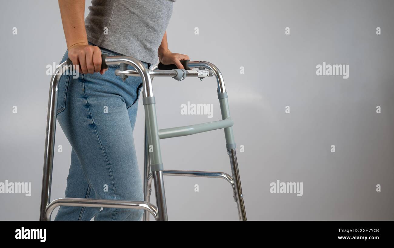 A woman is walking with a walker on a white background Stock Photo - Alamy