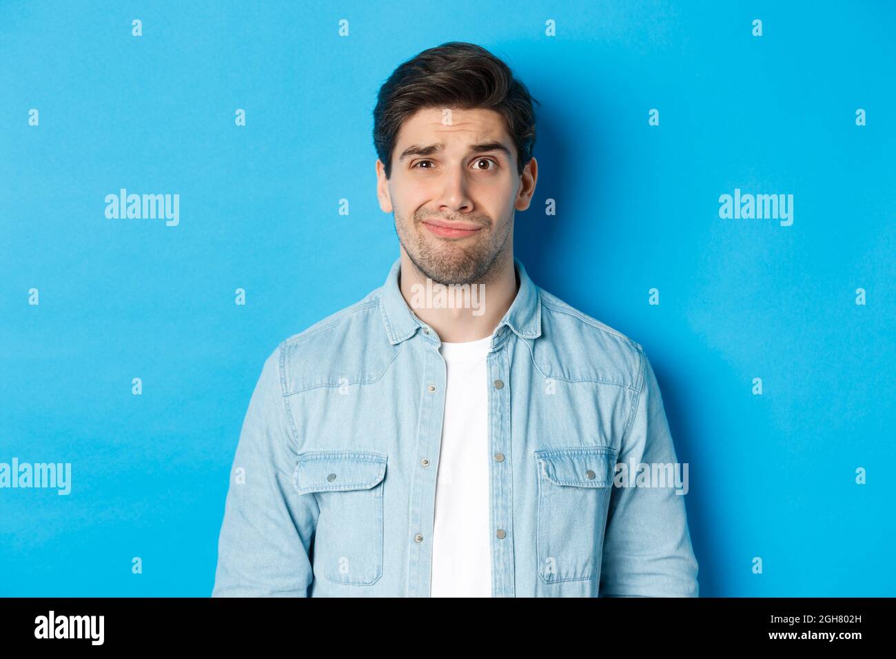 Close-up of skeptical and awkward guy smirking, feeling uncomfortable ...