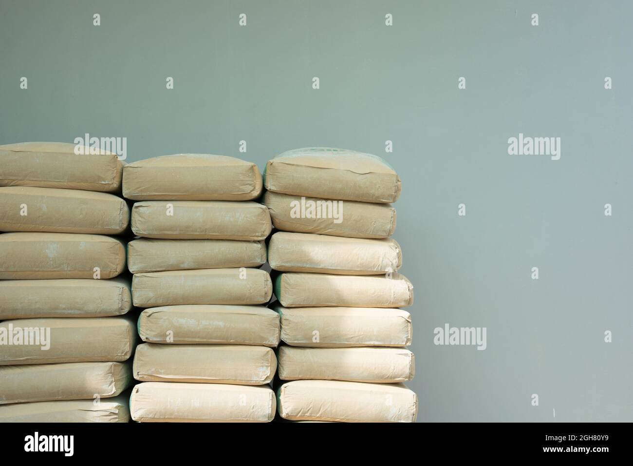 Pile of Cement in brown bags in a construction site with gray wall ...