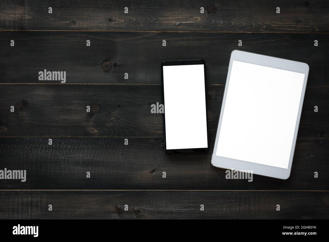 Mockup smartphone and tablet blank screen on a wooden table, top view ...