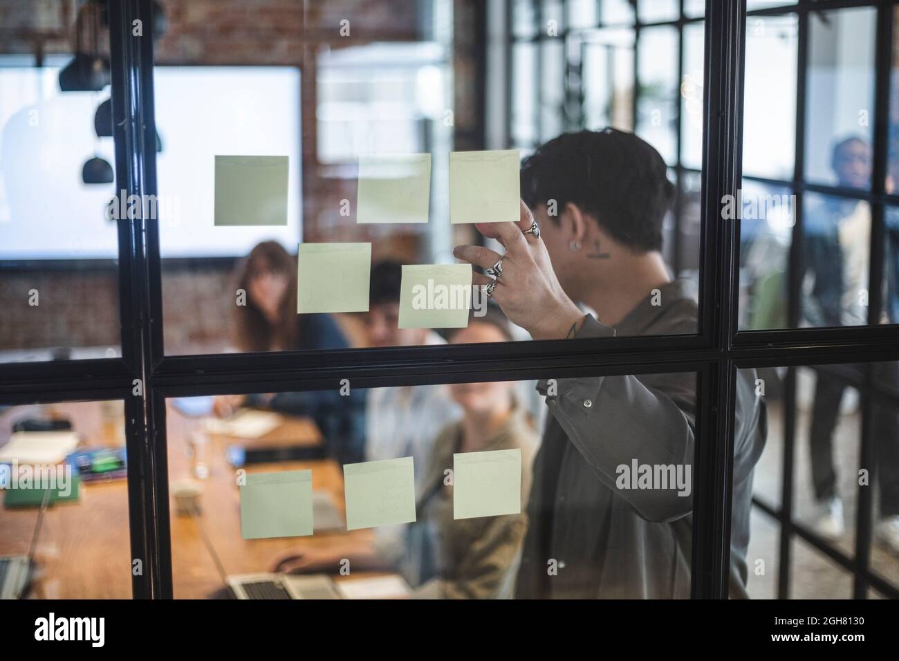 Male entrepreneur presenting business idea with colleagues in board ...