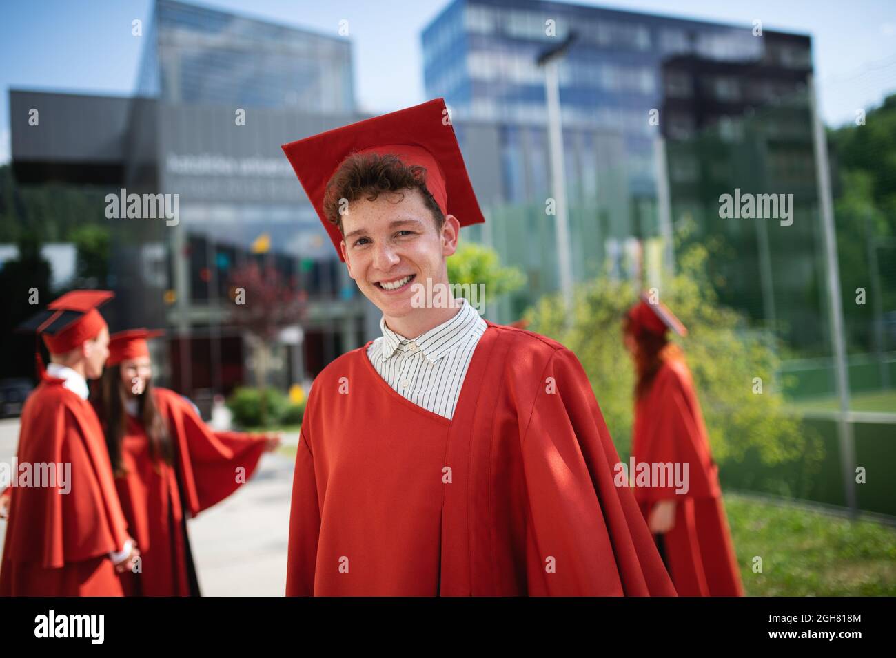 Portrait of cheerful male university student looking at camera ...