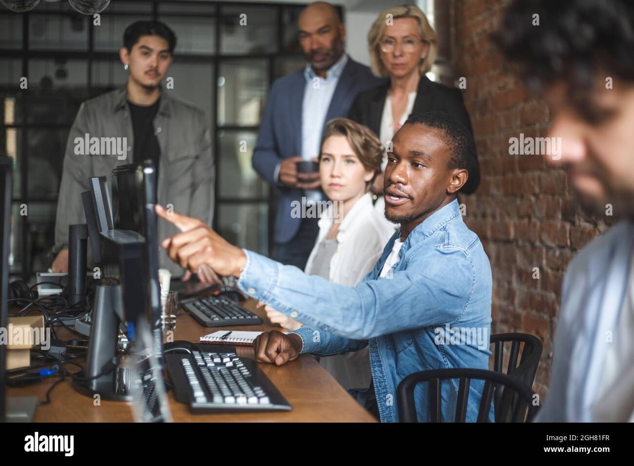 Male computer programmer discussing with investors at office Stock ...