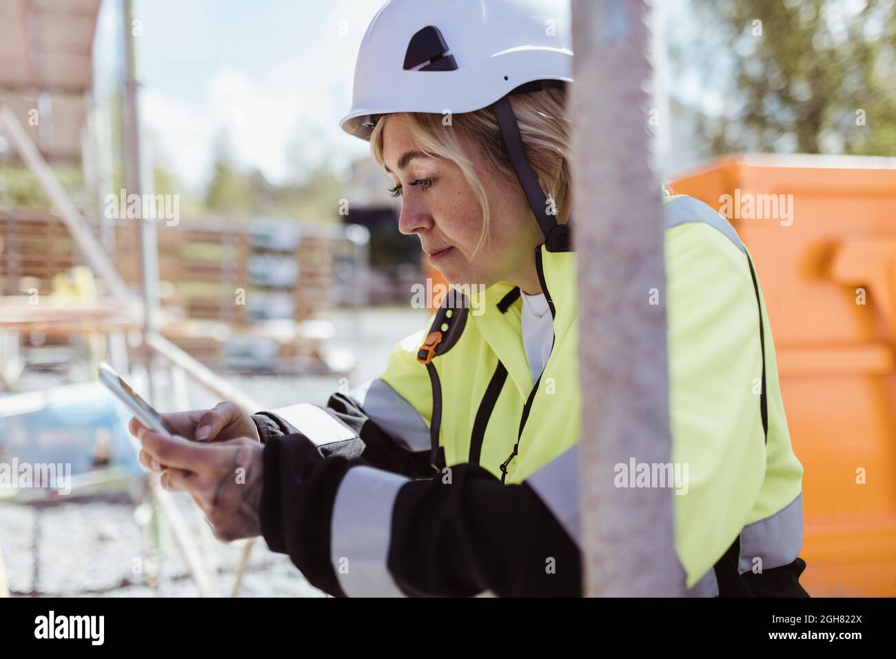 Female building contractor using smart phone at construction site Stock ...