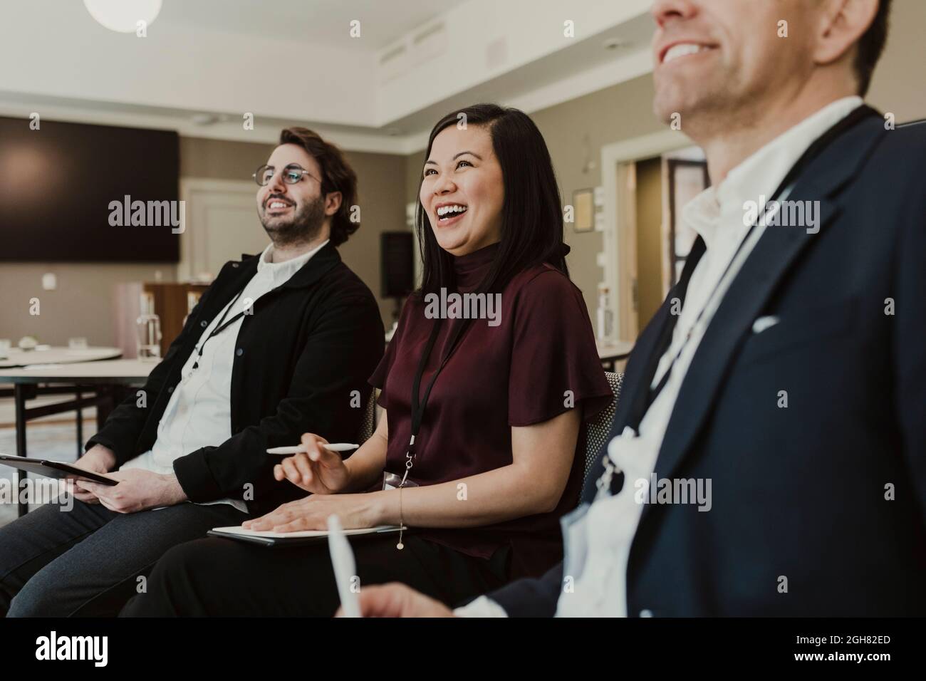 Business people laughing in discussion during meeting at education ...