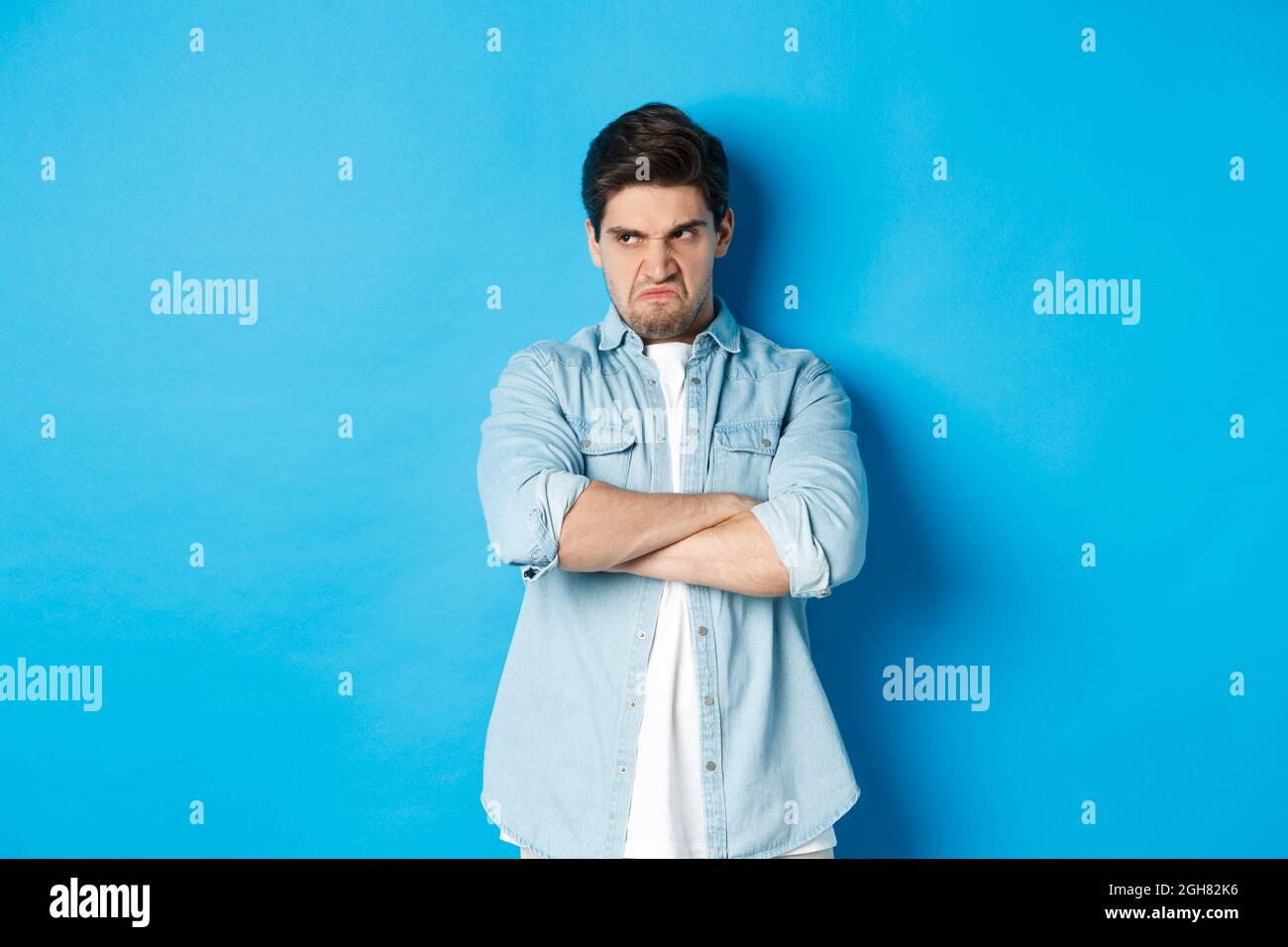 Angry guy cross arms on chest and looking away with insulted expression ...