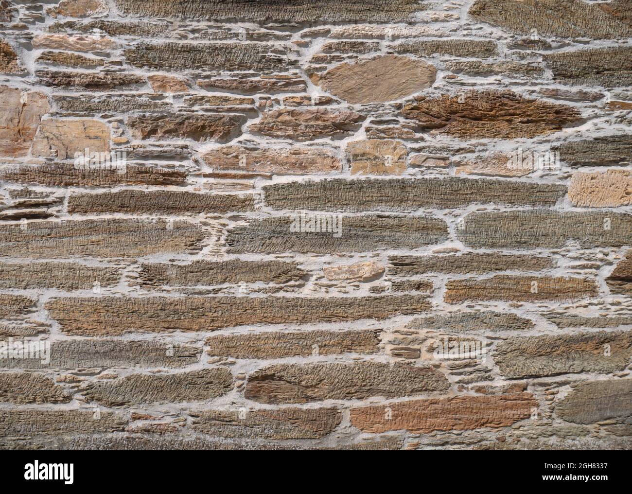 Ancient natural brown stone wall with gray cement background. Irregular ...