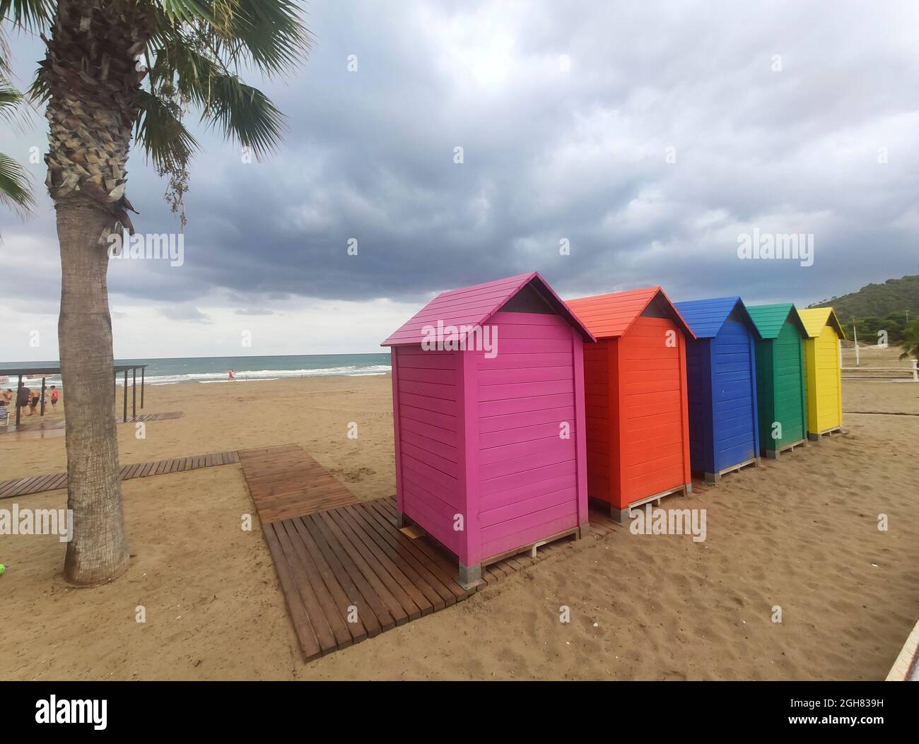 Wooden huts of various colors in the sand of Oropesa del Mar beach on a ...