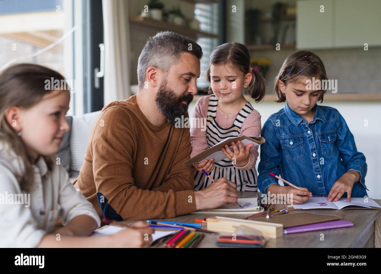Father with three daughters indoors at home, drawing pictures Stock ...