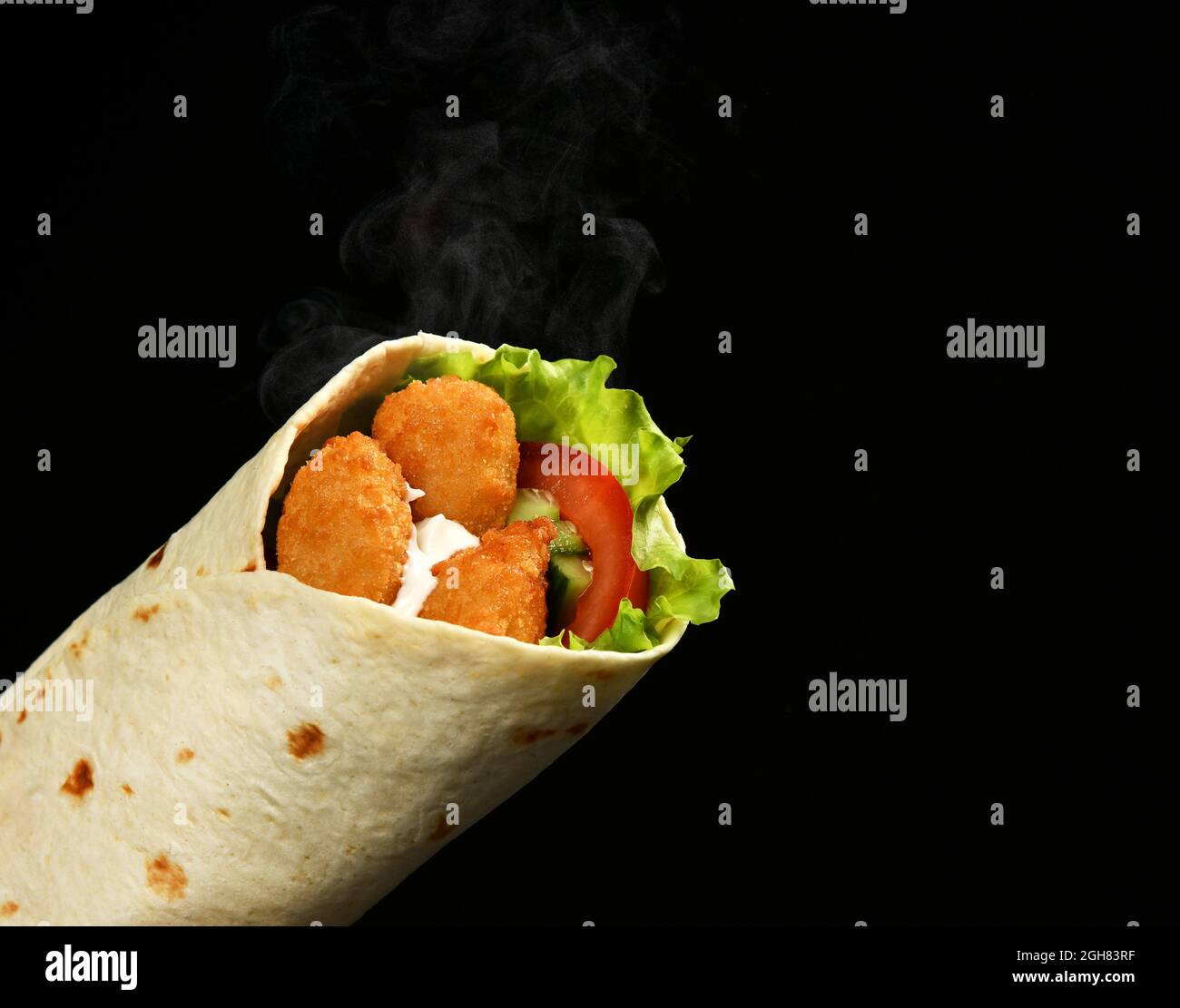 Classic tortilla wrap roll with nuggets and vegetables, tomato, lettuce ...
