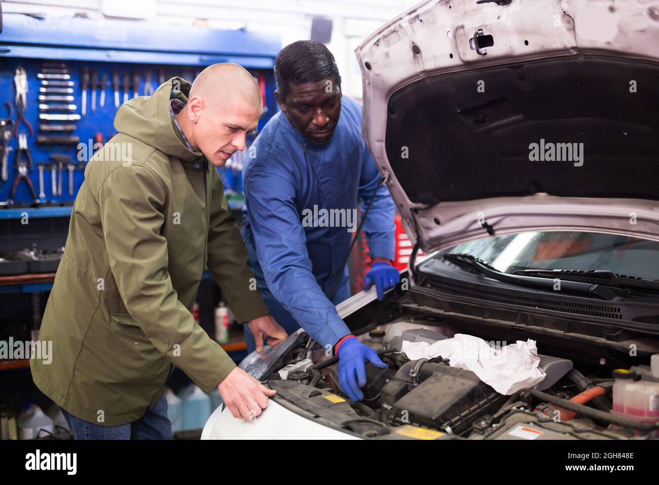 Two car mechanic diagnosing auto engine problem in auto service Stock ...