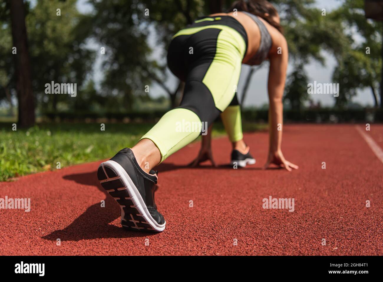 back view of sportswoman in starting pose on stadium Stock Photo - Alamy