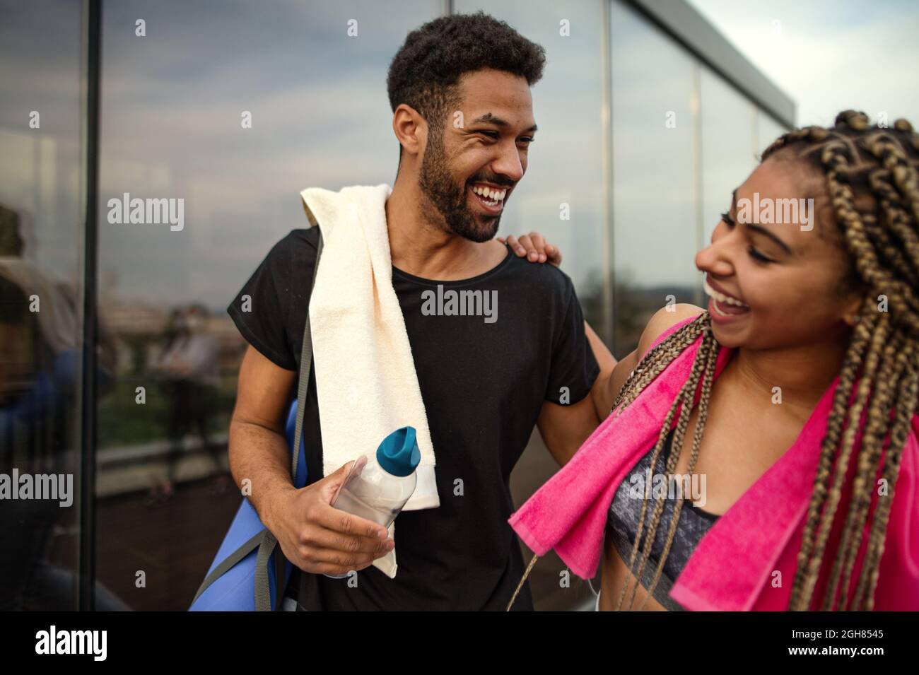Young couple talking after exercise outdoors on terrace, sport and ...