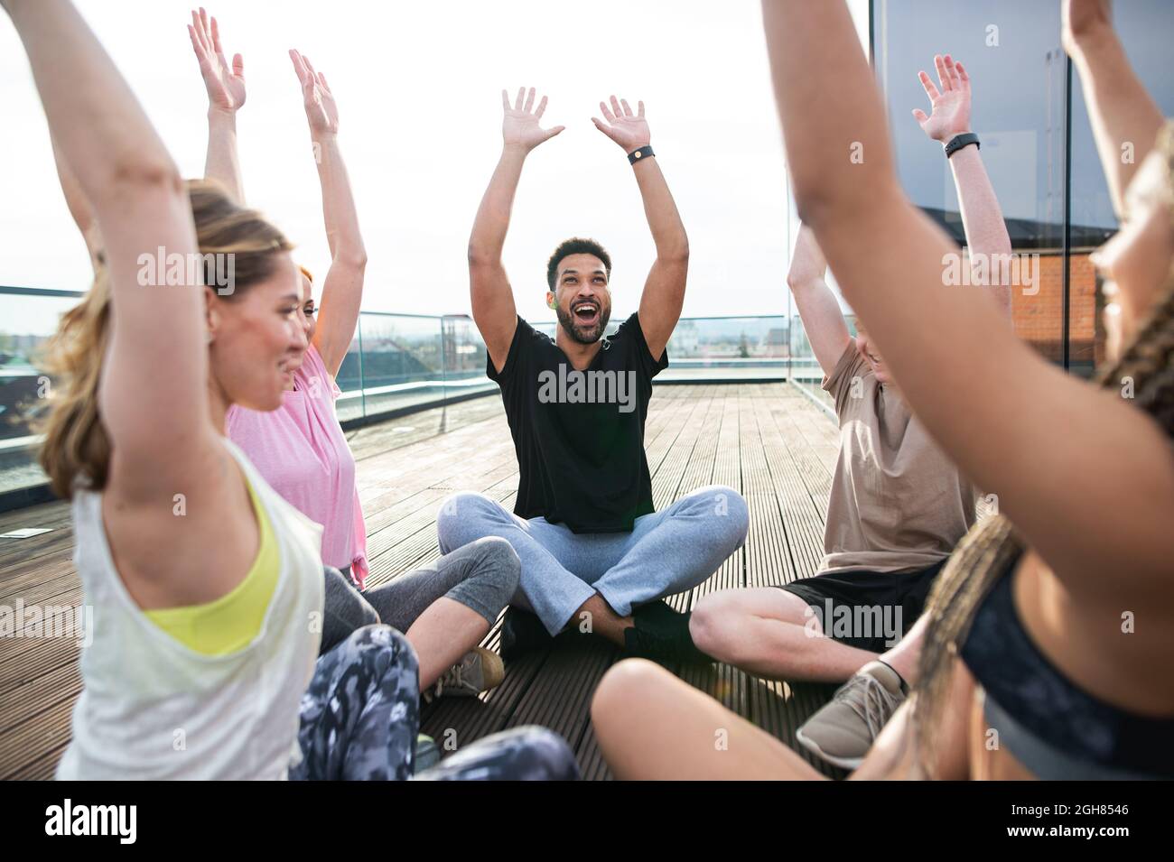 Group of young people doing exercise outdoors on terrace, sport and ...