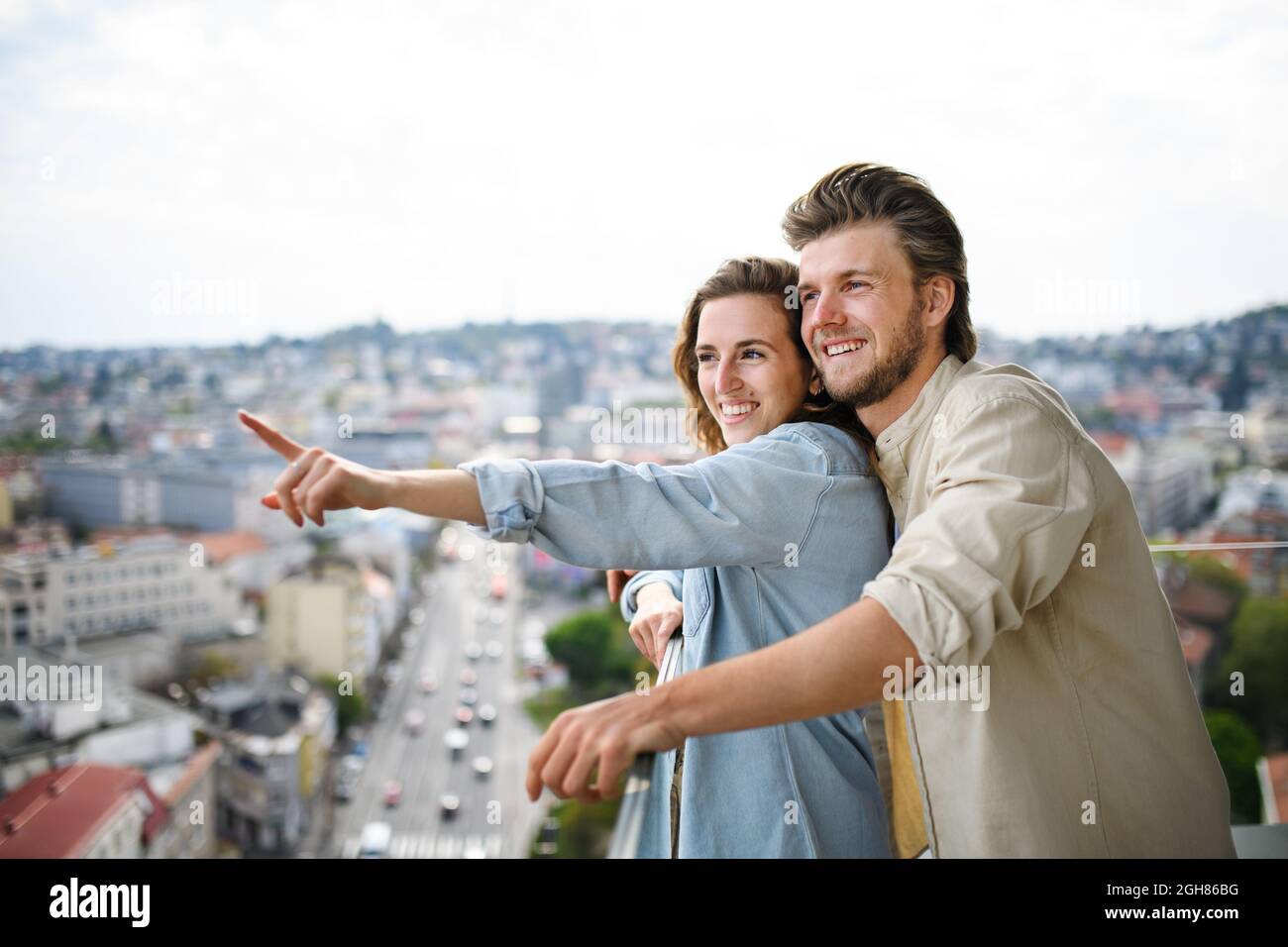 Happy young couple in love standing outdoors on balcony at home ...
