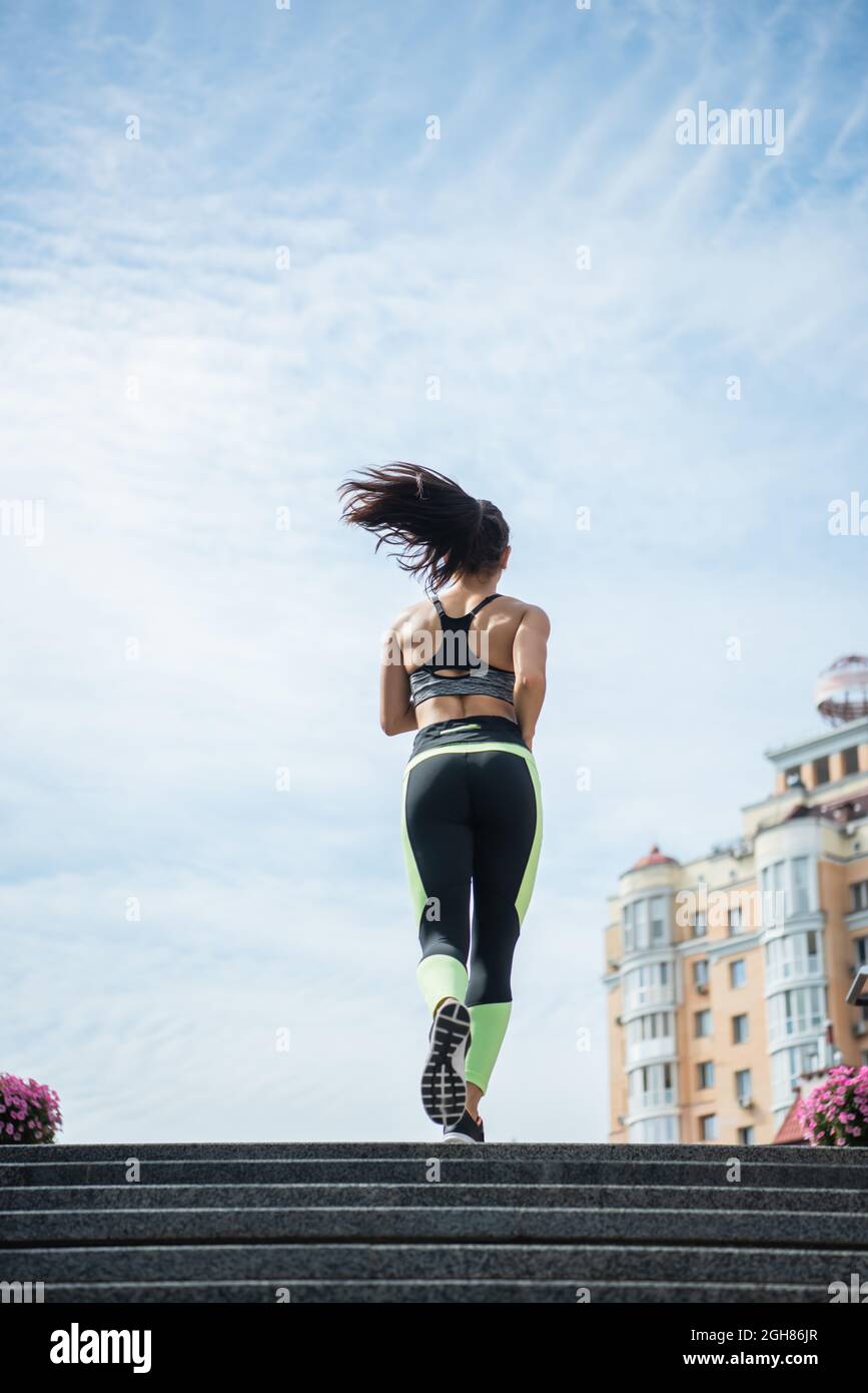 back view of sportive woman running on urban street Stock Photo - Alamy