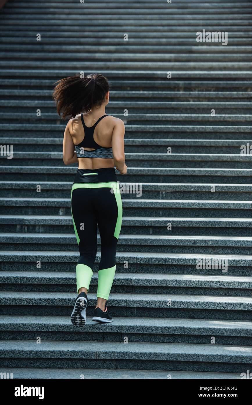 back view of sportive woman running on stairs outside Stock Photo - Alamy