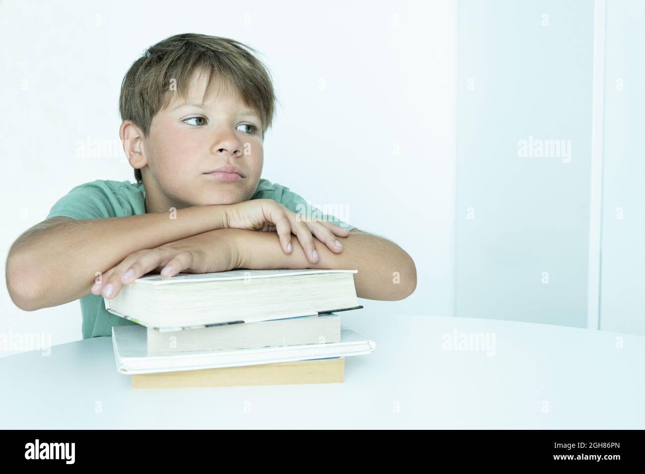 Sad boy with book does school homework. Back to school. Unhappy ...