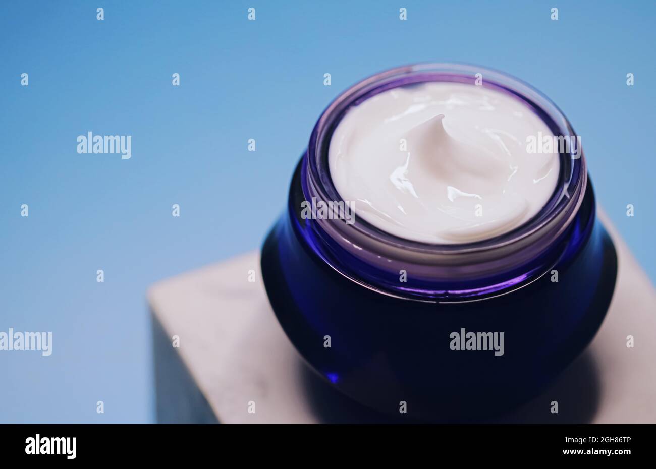 Anti-aging skincare and cosmetics, beauty face cream in jar on blue ...