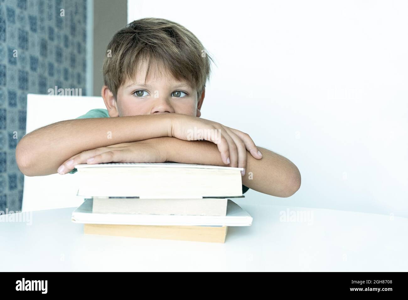 Sad boy with book does school homework. Back to school. Unhappy ...