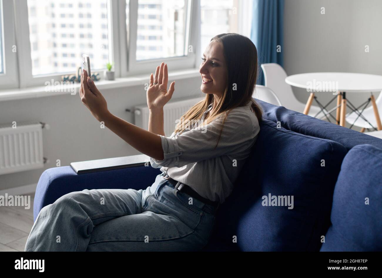 Attractive young woman making video call on the phone. Cheerful smiling ...