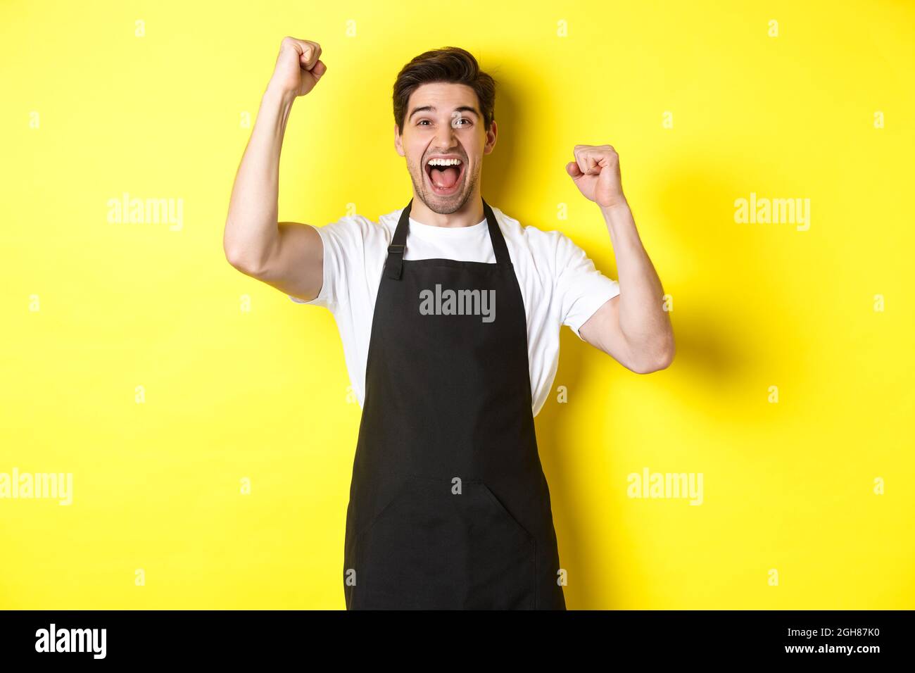 Happy barista celebrating victory, raising hands up and shouting for ...