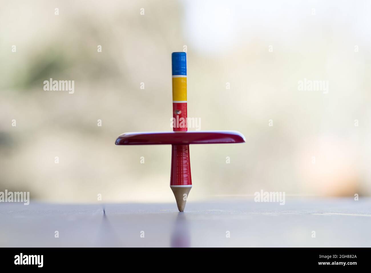 Colorful wooden peg-top or a teetotum on a blurred background Stock ...