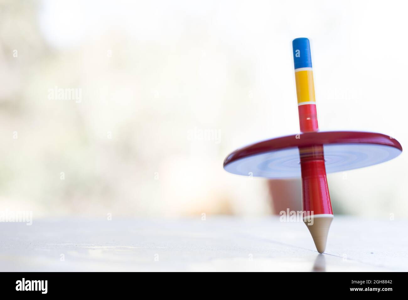 Colorful wooden peg-top or a teetotum with copy space on the left Stock ...